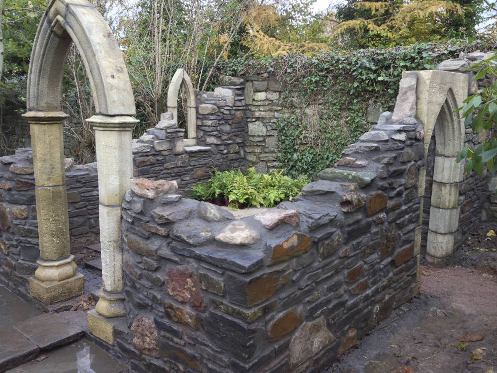 Folly design with arched windows and doors within a South Wales garden ...